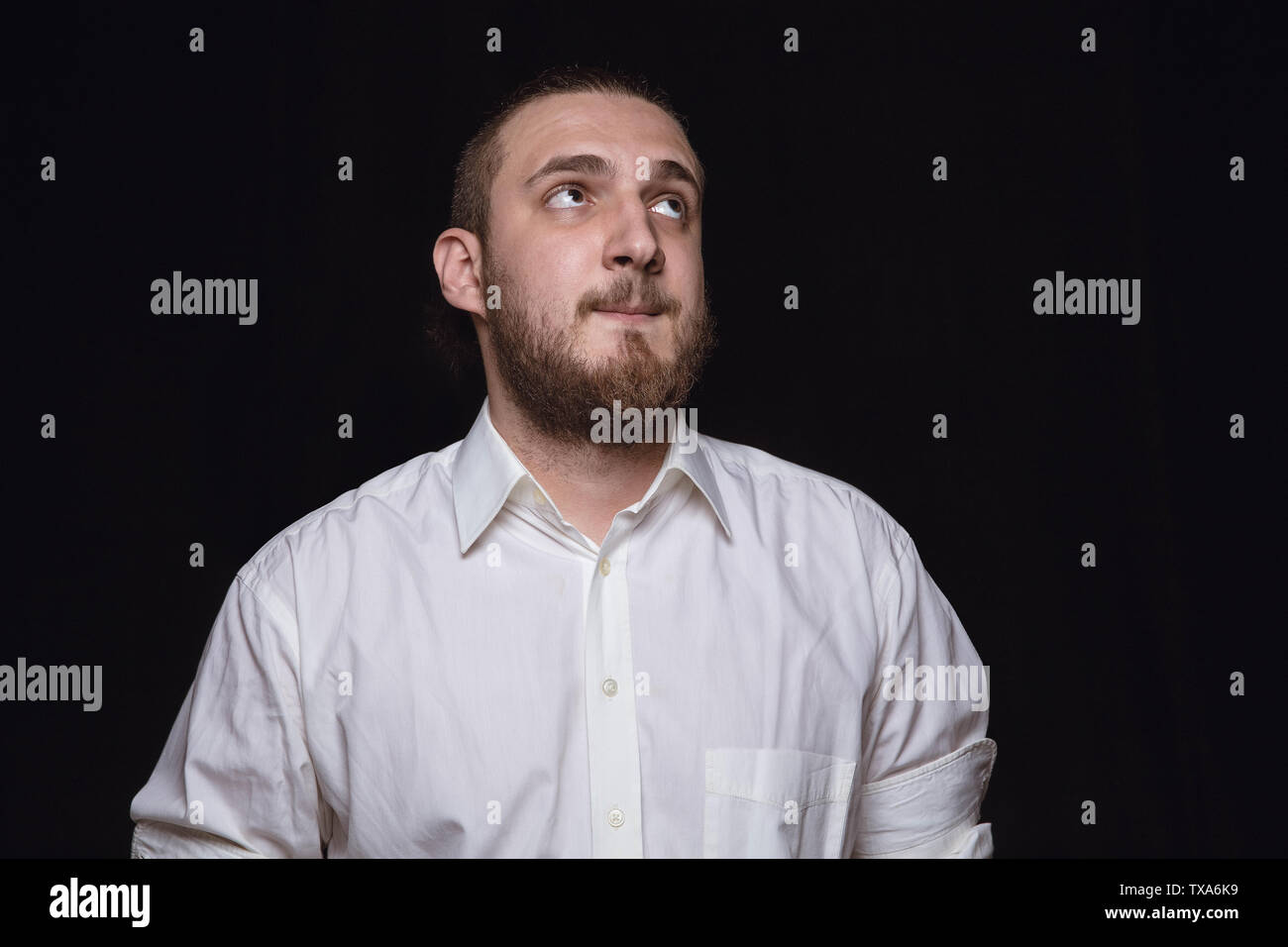 Close up portrait of young man isolated on black studio background ...