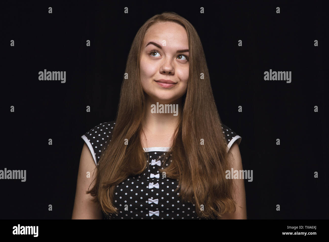 Close up portrait of young woman isolated on black studio background ...