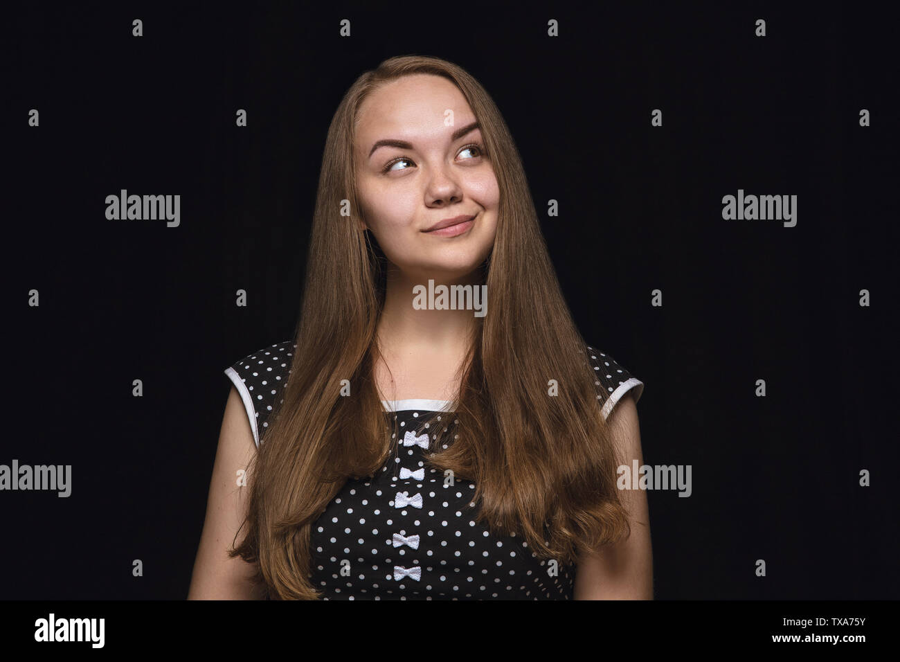 Close up portrait of young woman isolated on black studio background ...