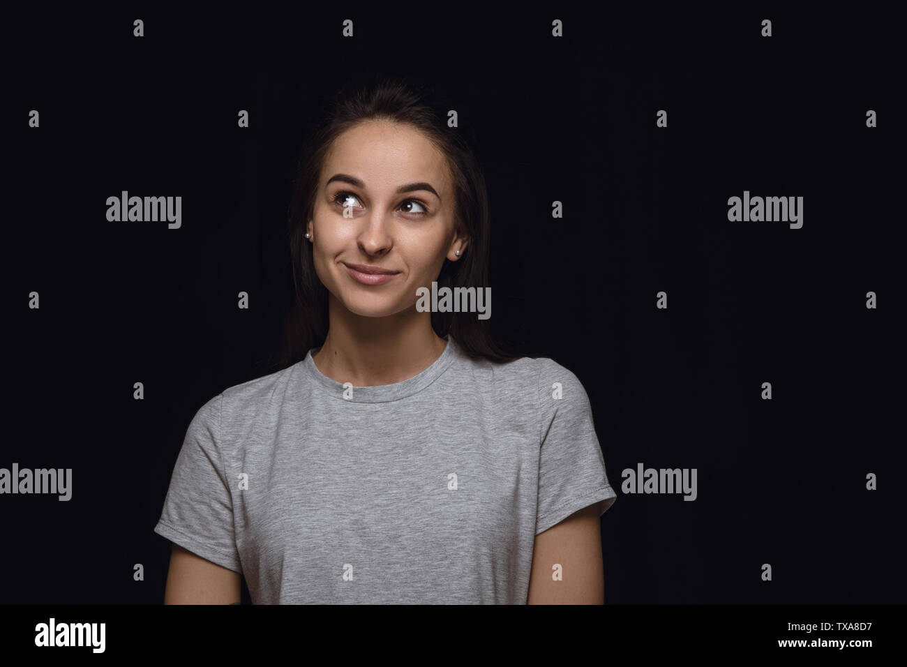 Close up portrait of young woman isolated on black studio background ...