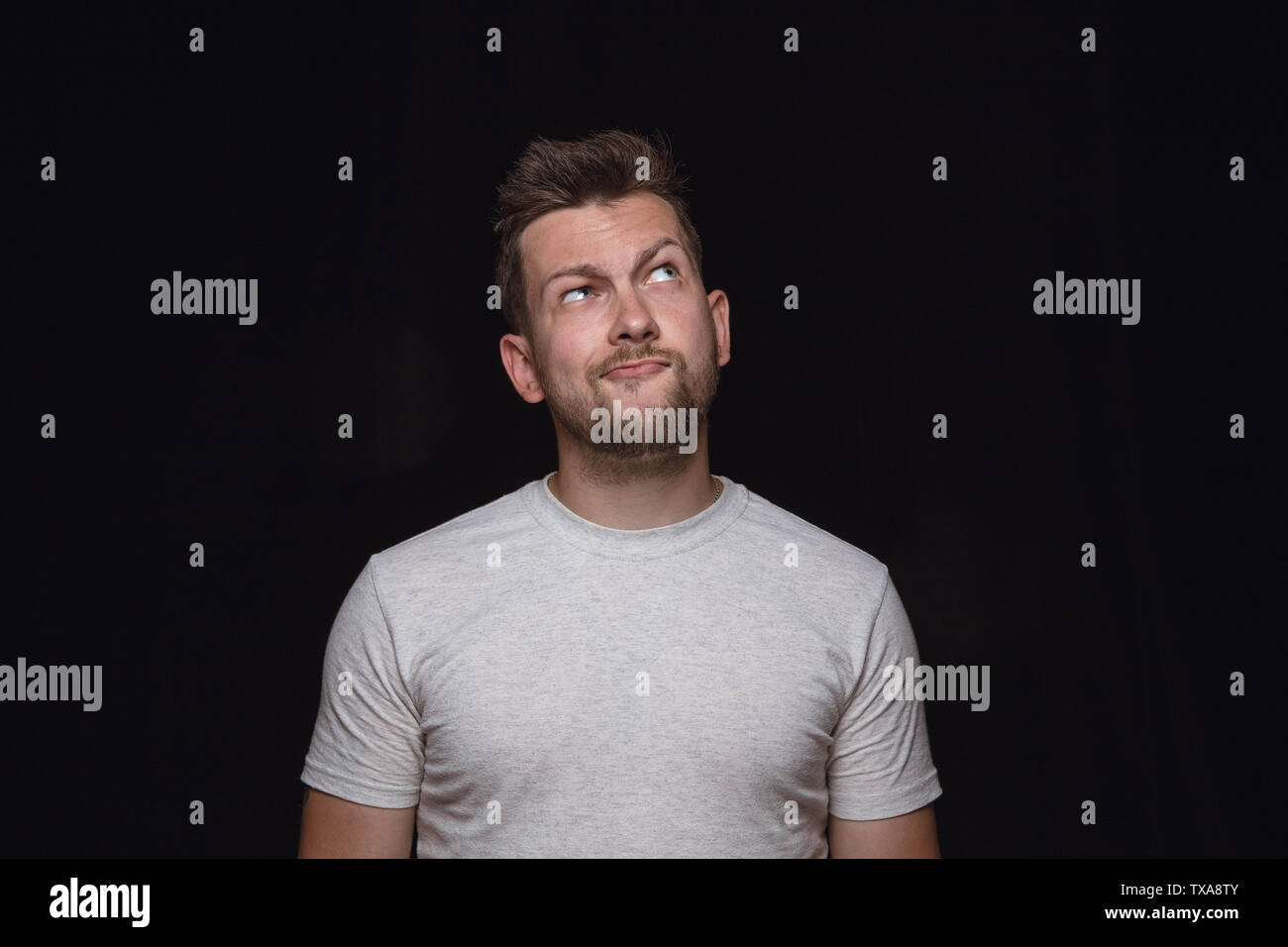 Close up portrait of young man isolated on black studio background ...