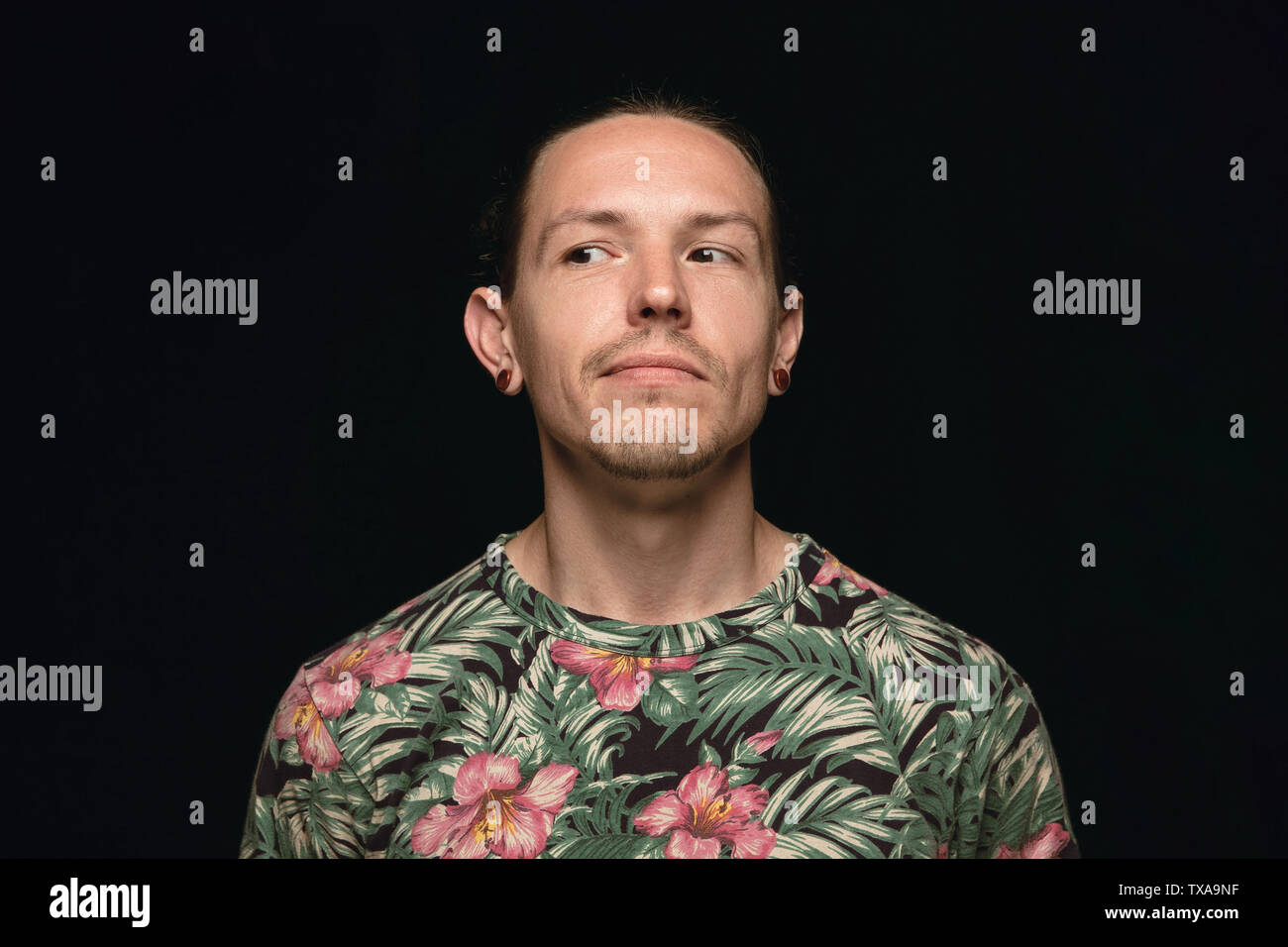 Close up portrait of young man isolated on black studio background ...