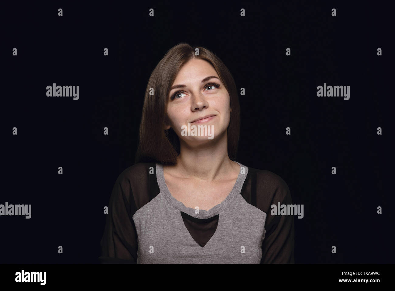 Close up portrait of young woman isolated on black studio background ...