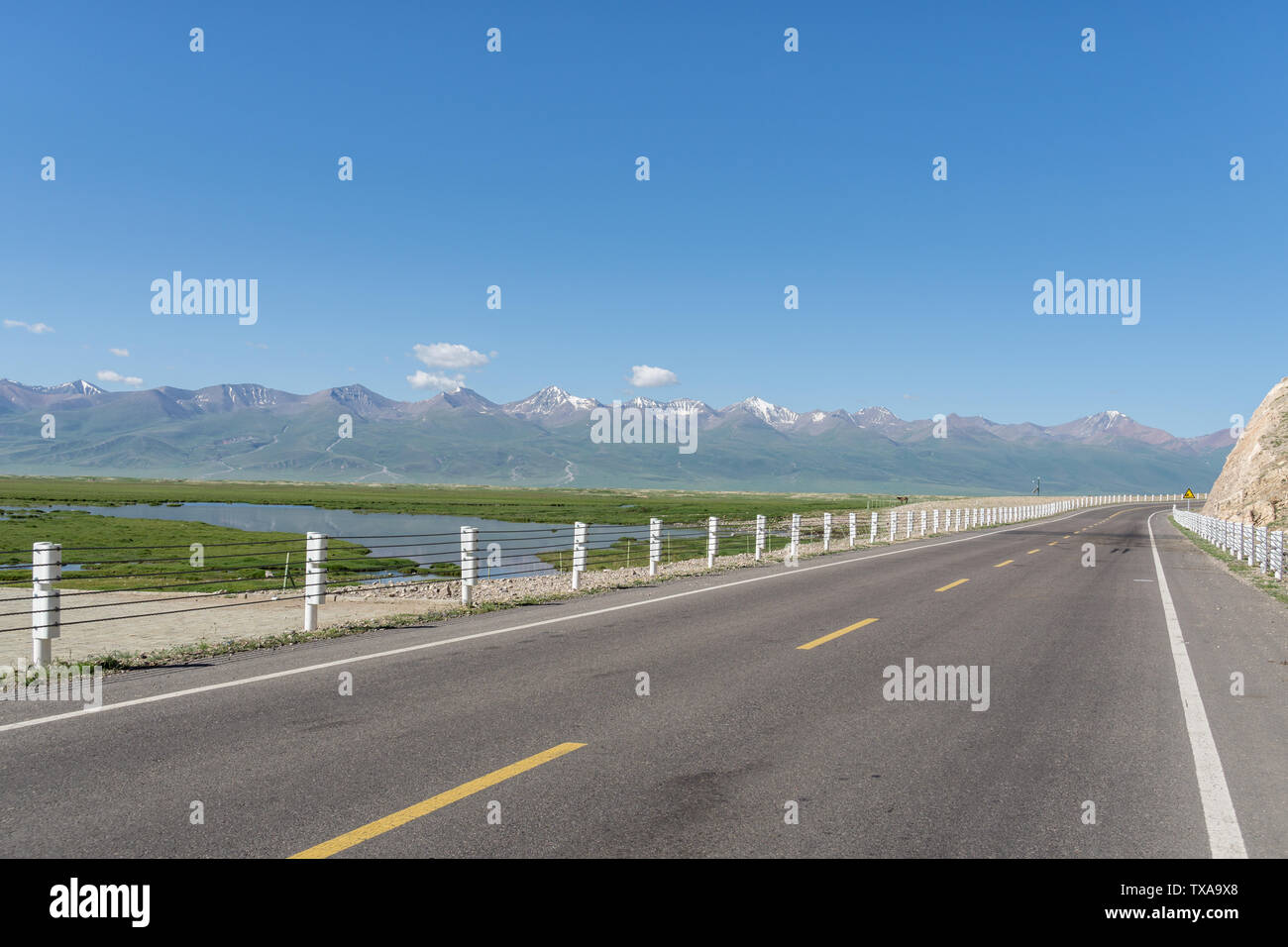 Summer Xinjiang alpine grassland road car background Stock Photo - Alamy