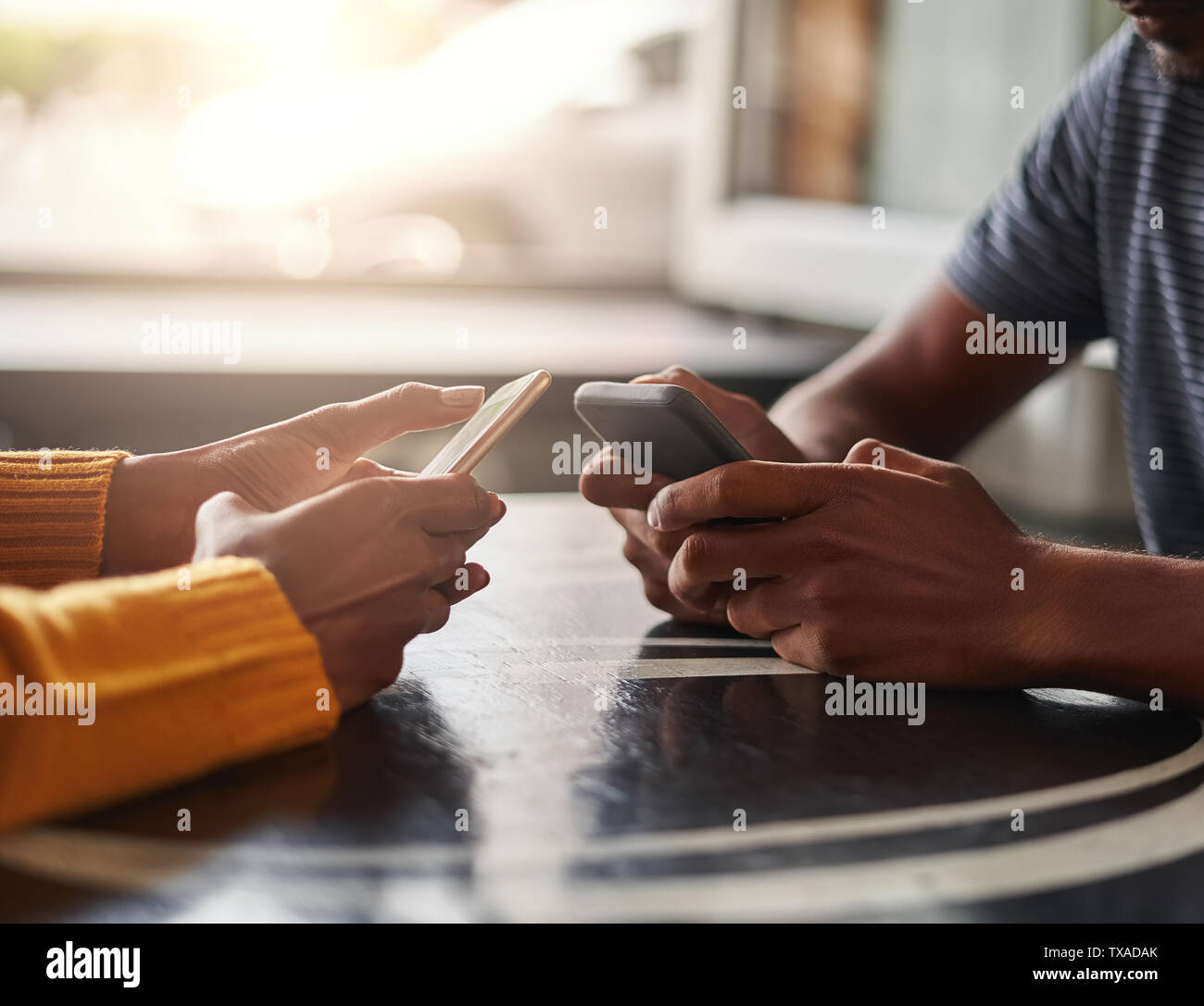 Couple using their mobile phones in cafe Stock Photo - Alamy