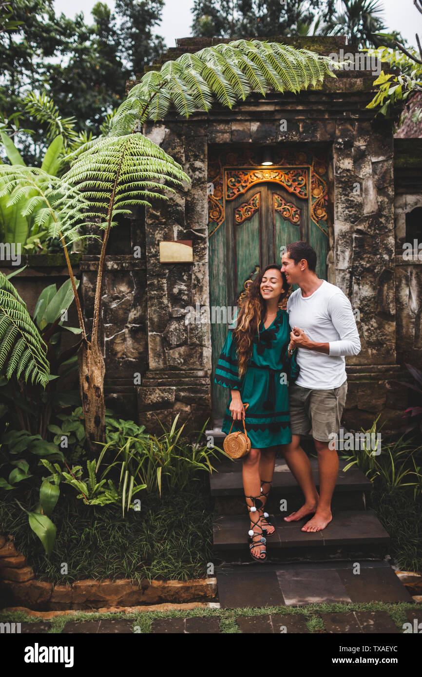 Happy couple in love smiling and kissing on background of traditional ...