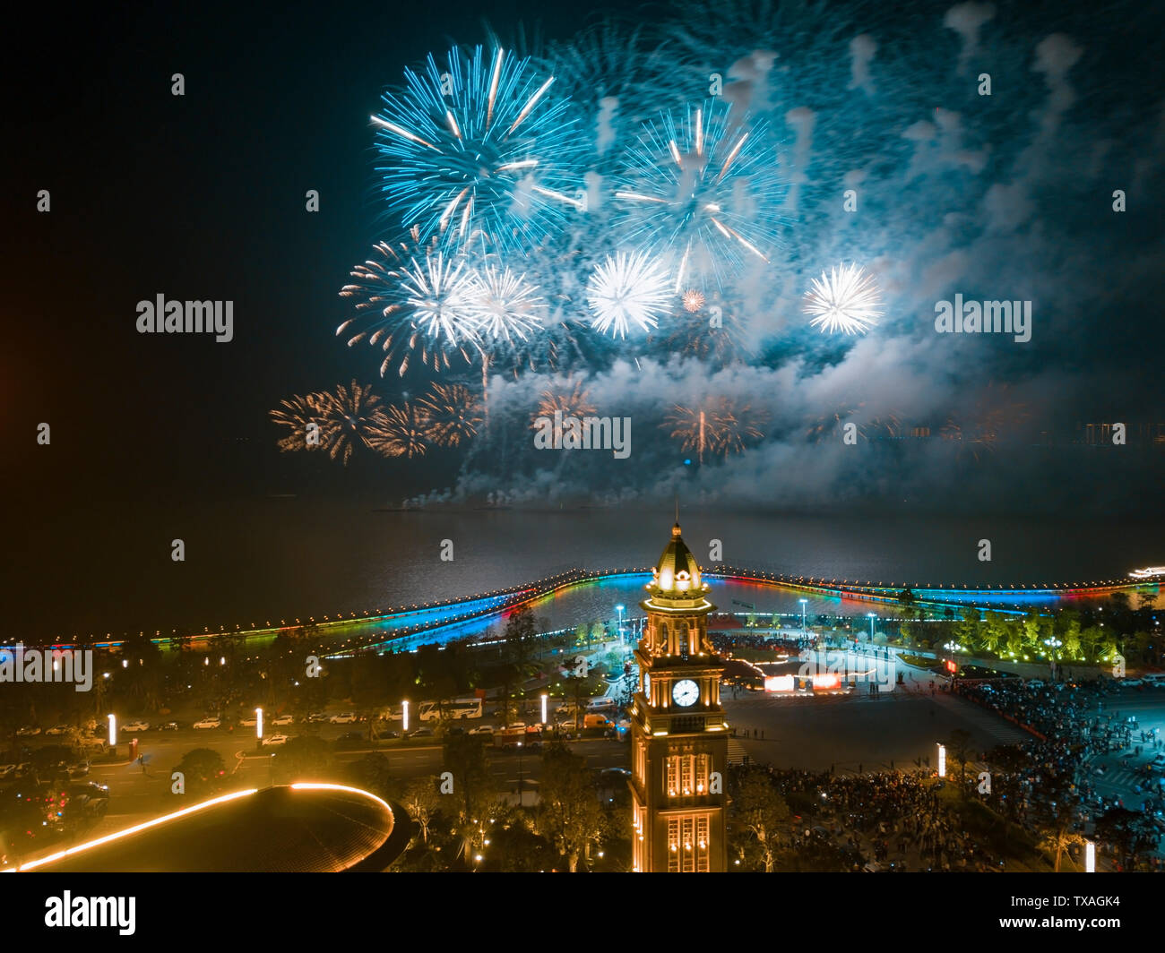Night view of fireworks under tower landmark, blooming at sea, colorful ...