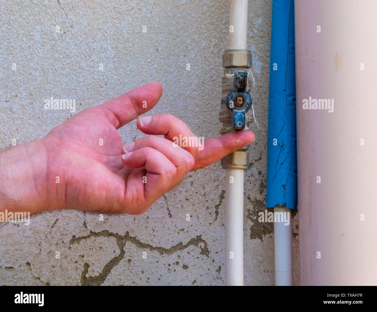 Hand using an old rusty faucet on a pipe outside Stock Photo - Alamy
