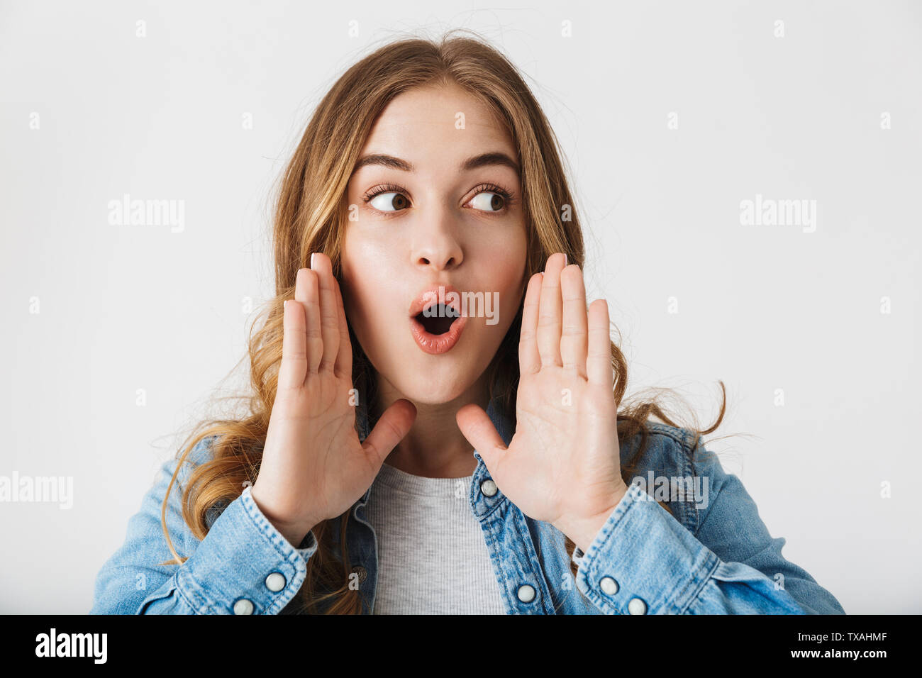 Attractive young girl standing isolated over white background, shouting ...