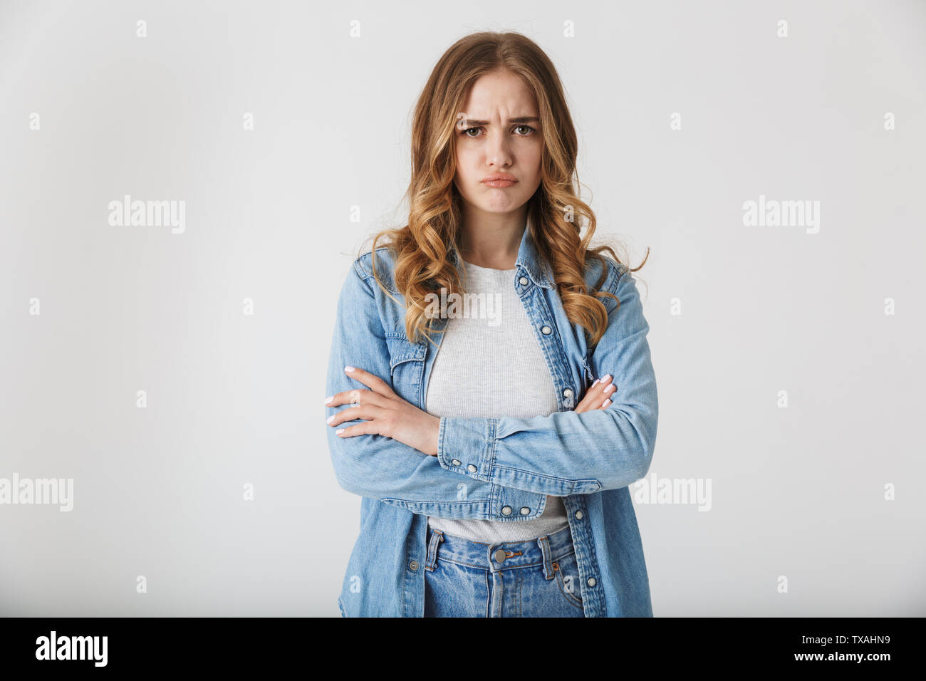 Attractive angry young girl standing isolated over white background ...