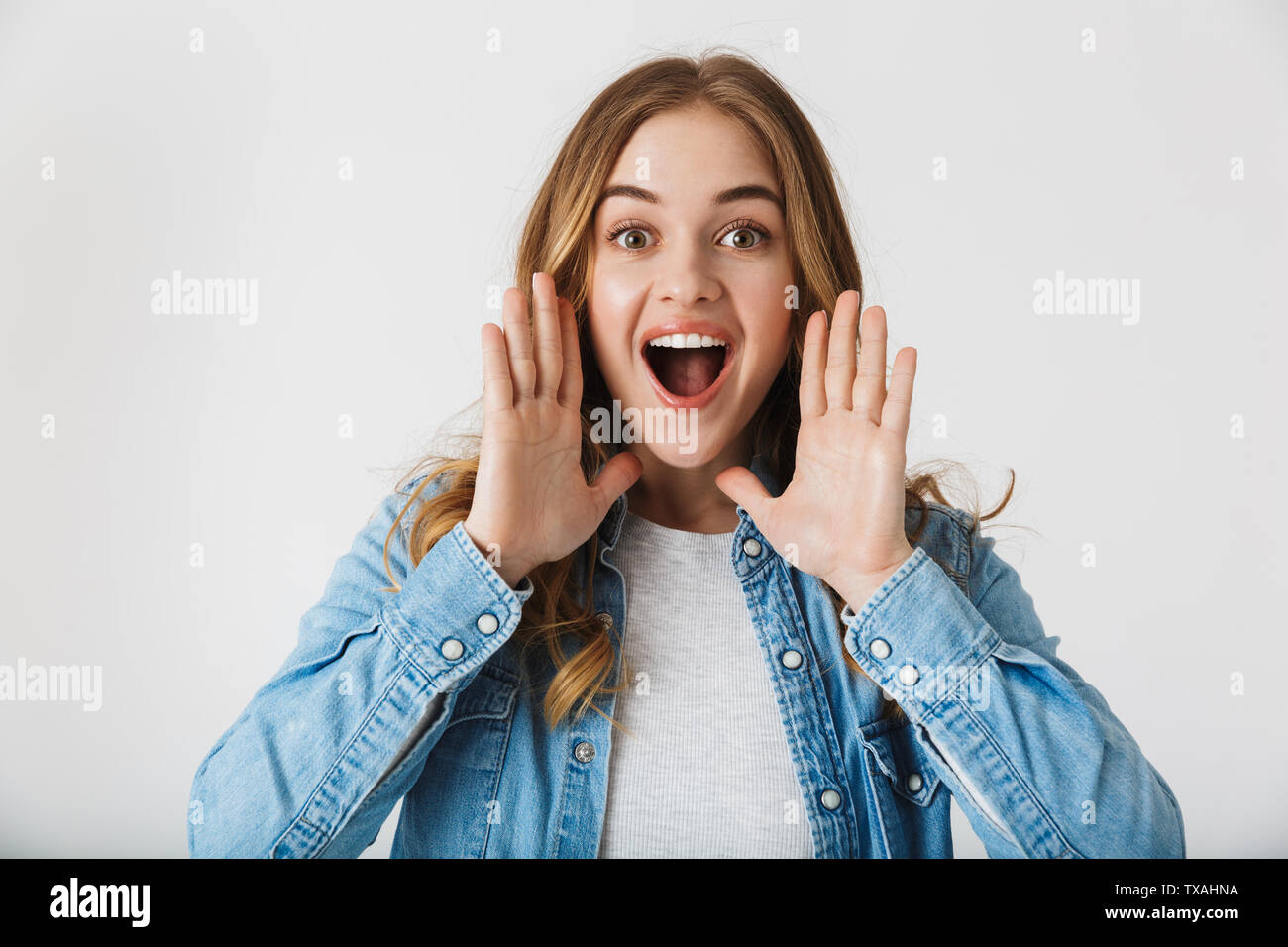 Attractive young girl standing isolated over white background, shouting ...