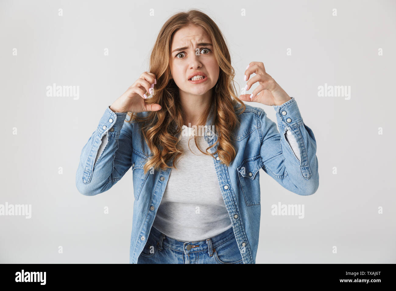 Attractive scared young girl standing isolated over white background ...