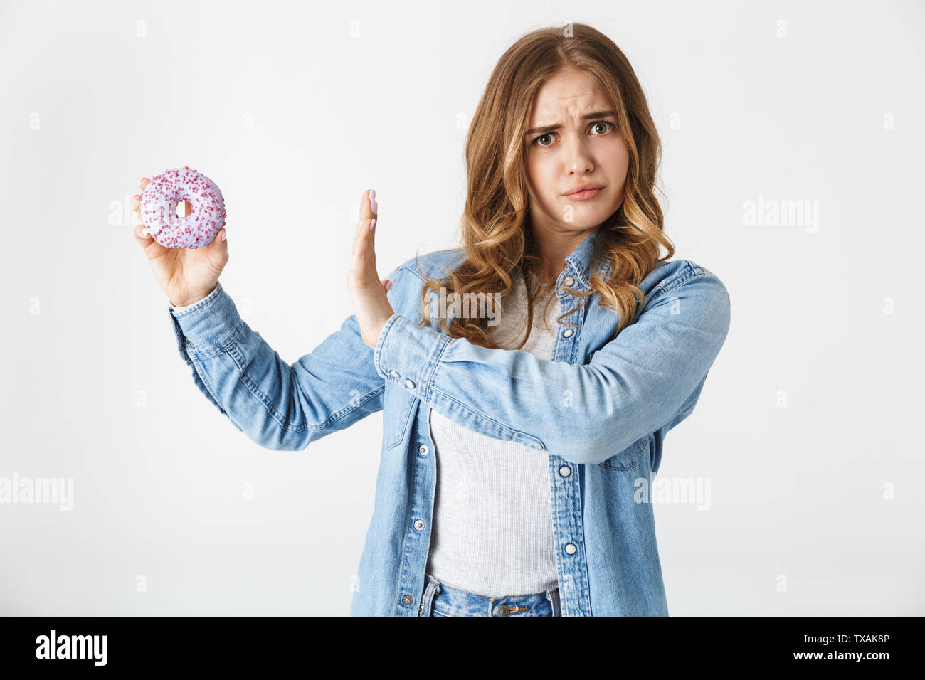 Attractive confused young girl standing isolated over white background ...