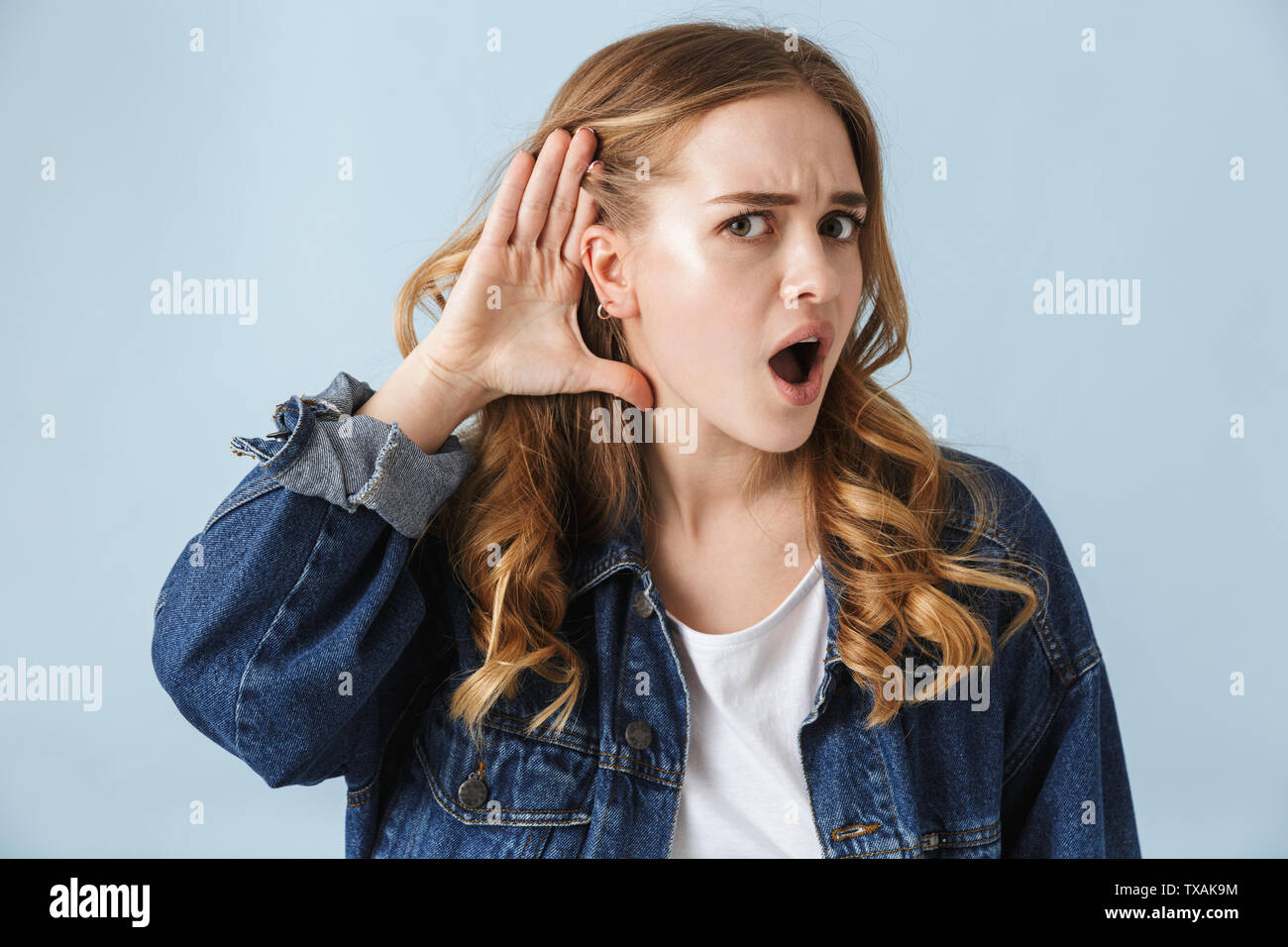 Attractive young girl standing isolated over white background, trying ...