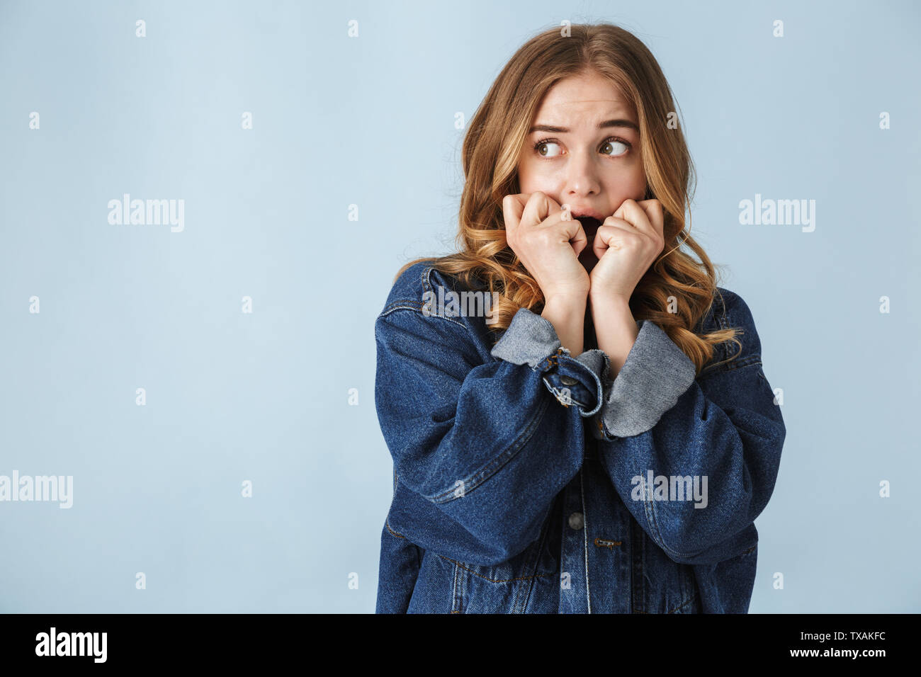 Attractive scared young girl standing isolated over white background ...