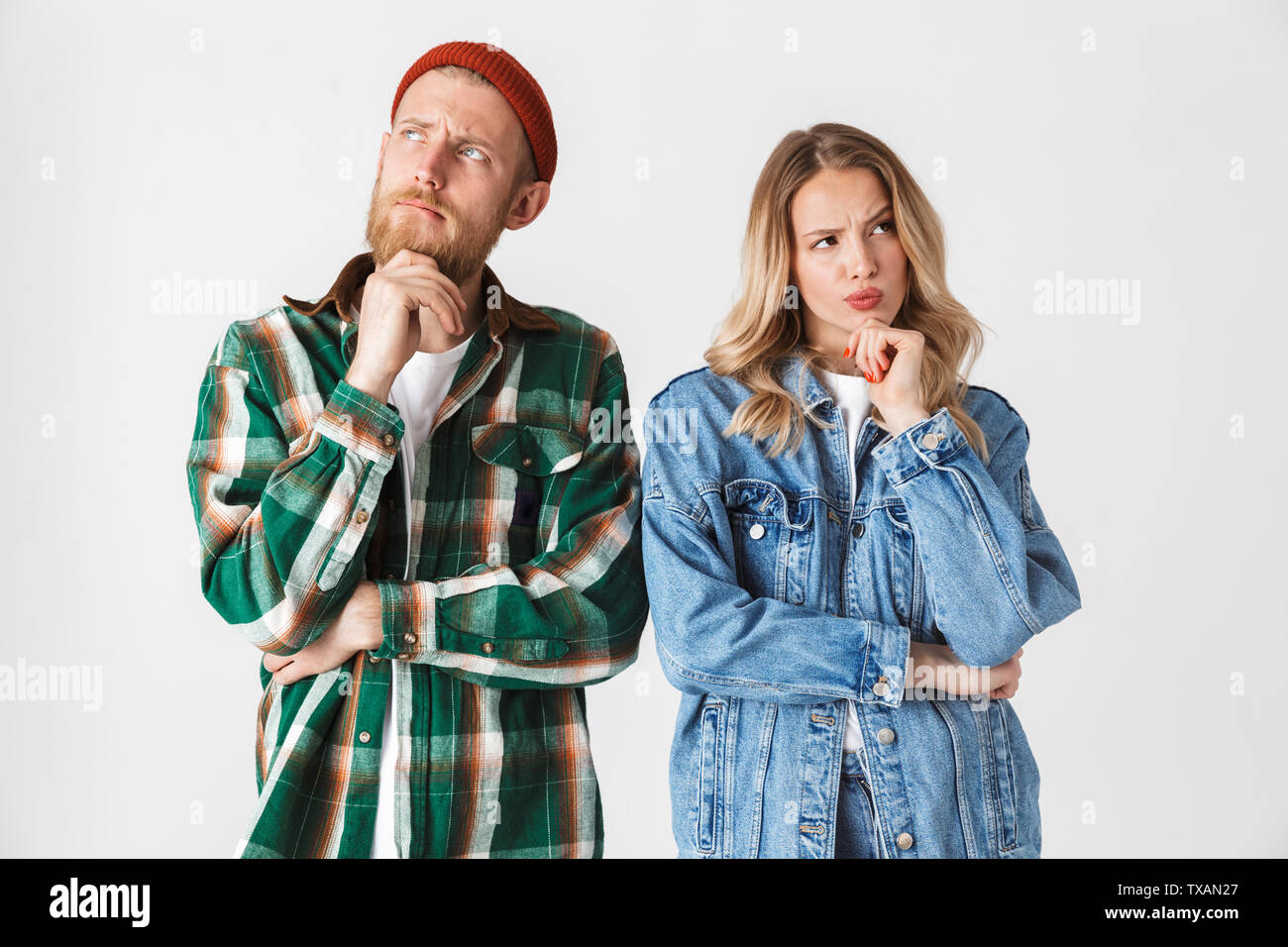 Photo of a thinking young loving couple posing isolated over white wall ...