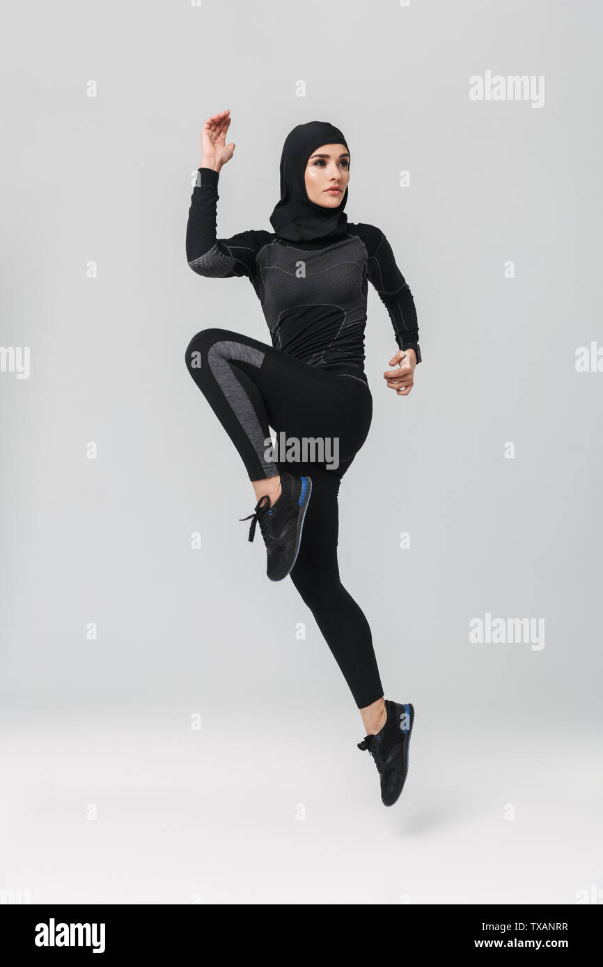 Image of young woman fitness muslim posing running jumping isolated ...