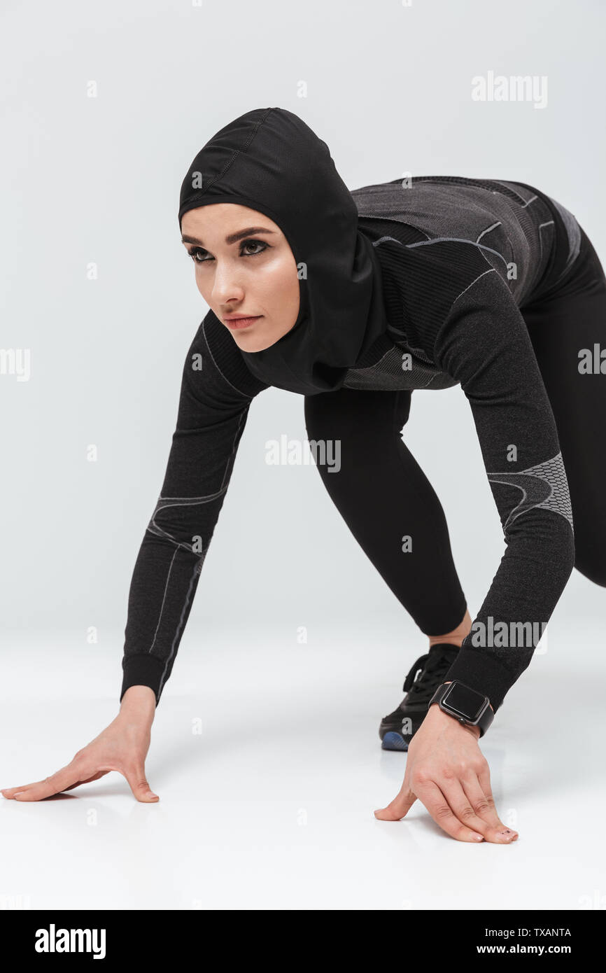 Image of young woman fitness muslim doing exercise isolated over white ...