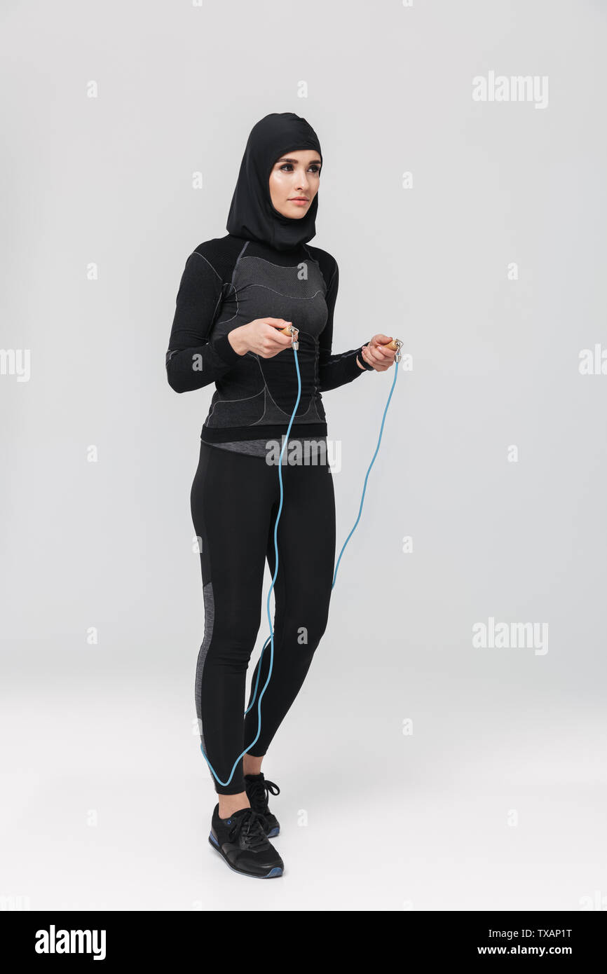 Image of young woman fitness muslim posing isolated over white wall ...