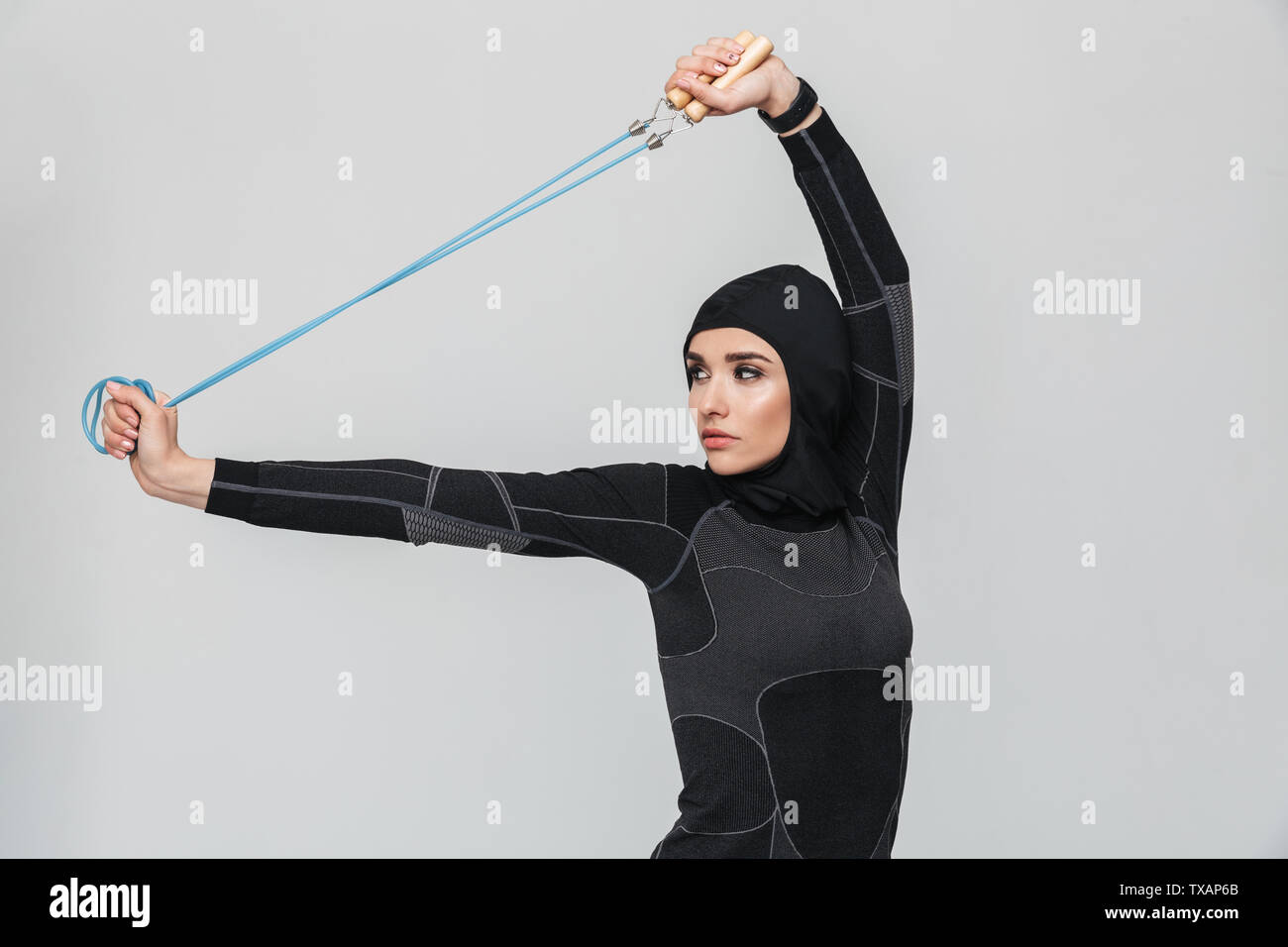 Image of young woman fitness muslim make exercises with skipping rope ...