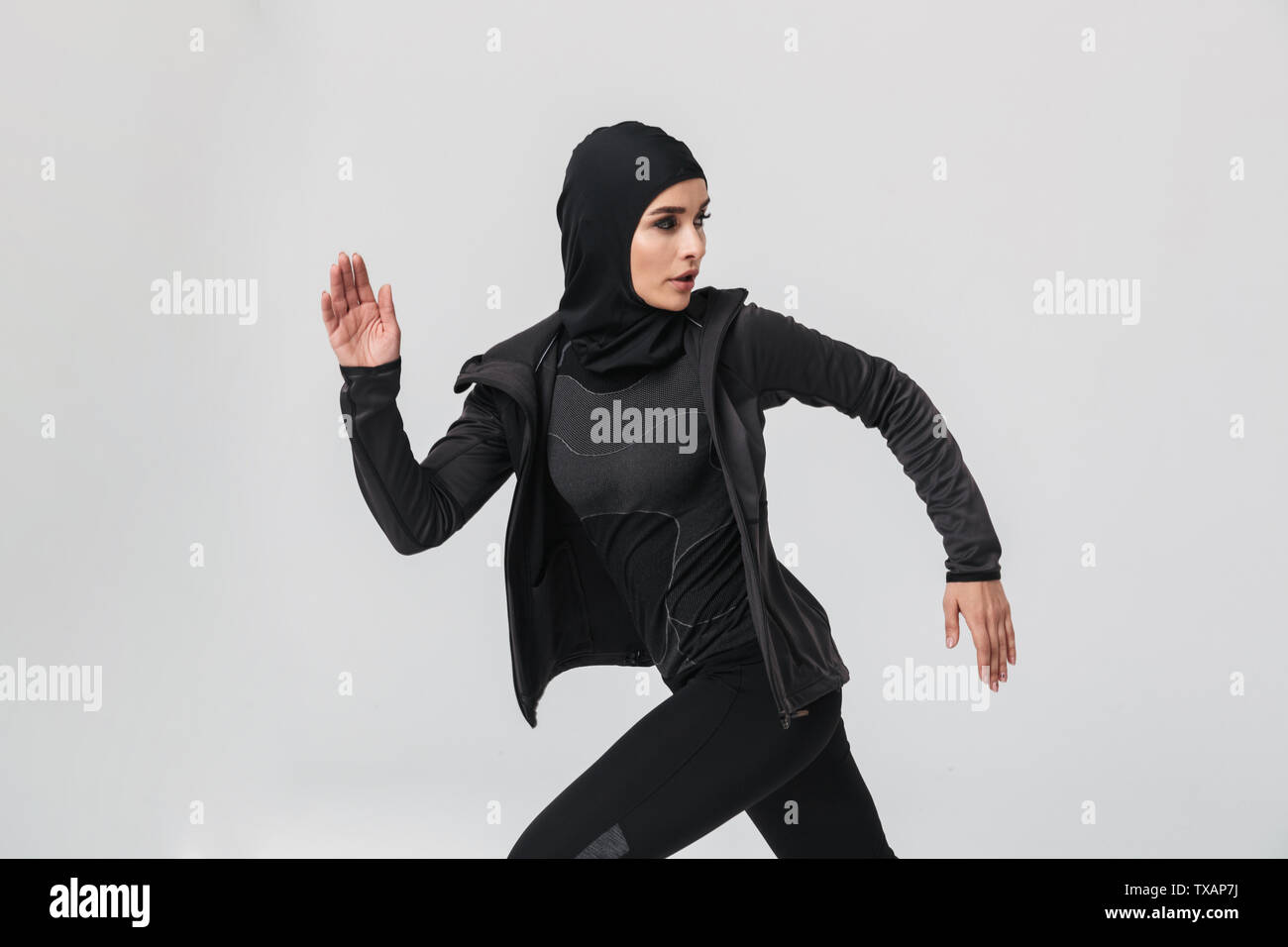 Attractive confident young muslim woman wearing sport hijab running ...