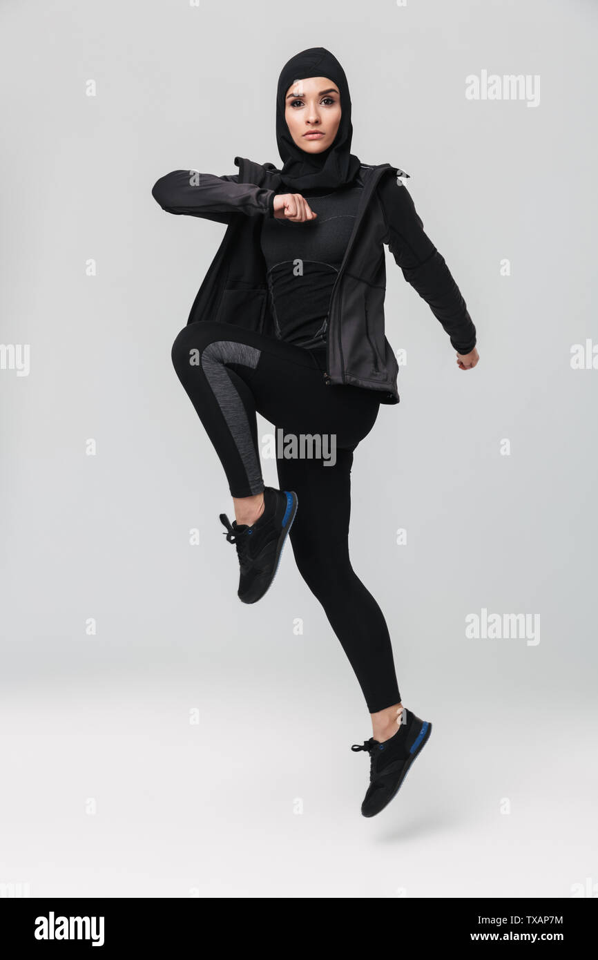 Image of young woman fitness muslim posing running jumping isolated ...