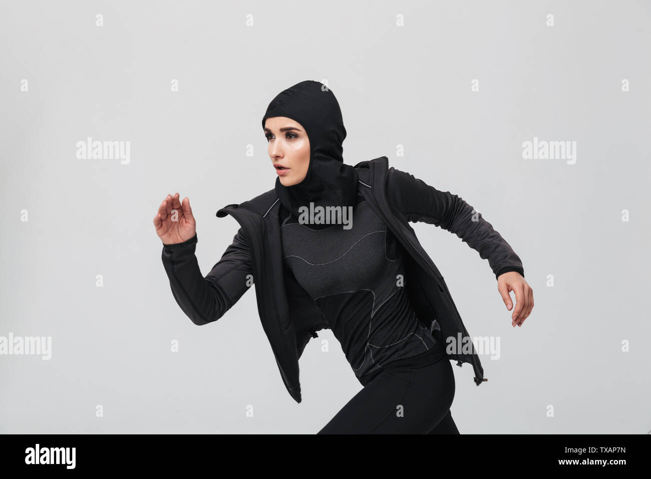 Attractive confident young muslim woman wearing sport hijab running ...