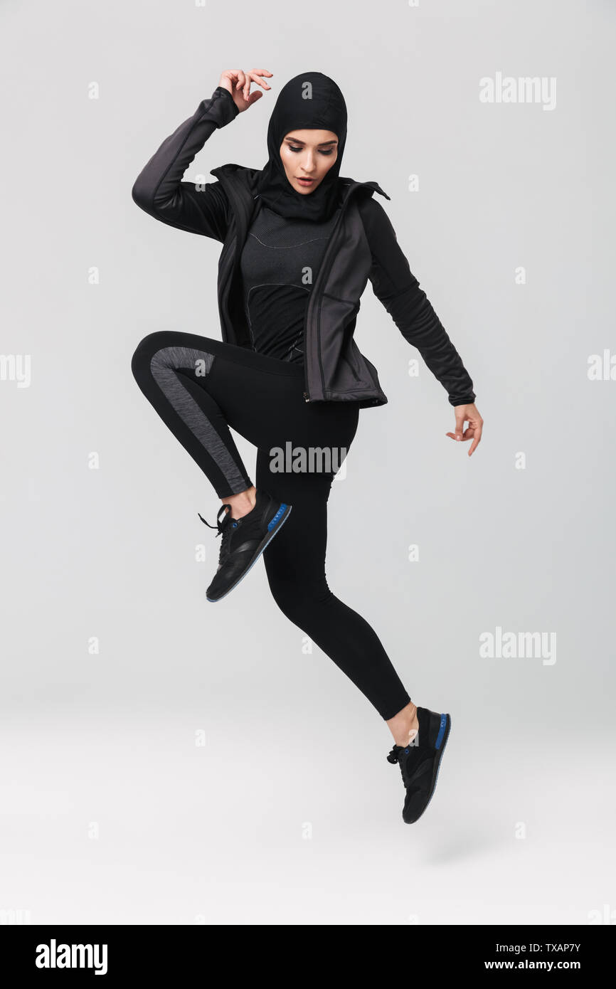 Image of young woman fitness muslim posing running jumping isolated ...