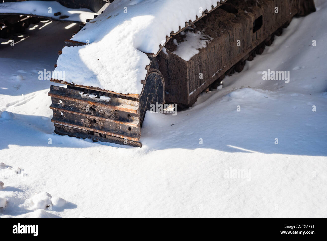 Part of heavy industrial continuous tracks casting shadow on snow Stock ...