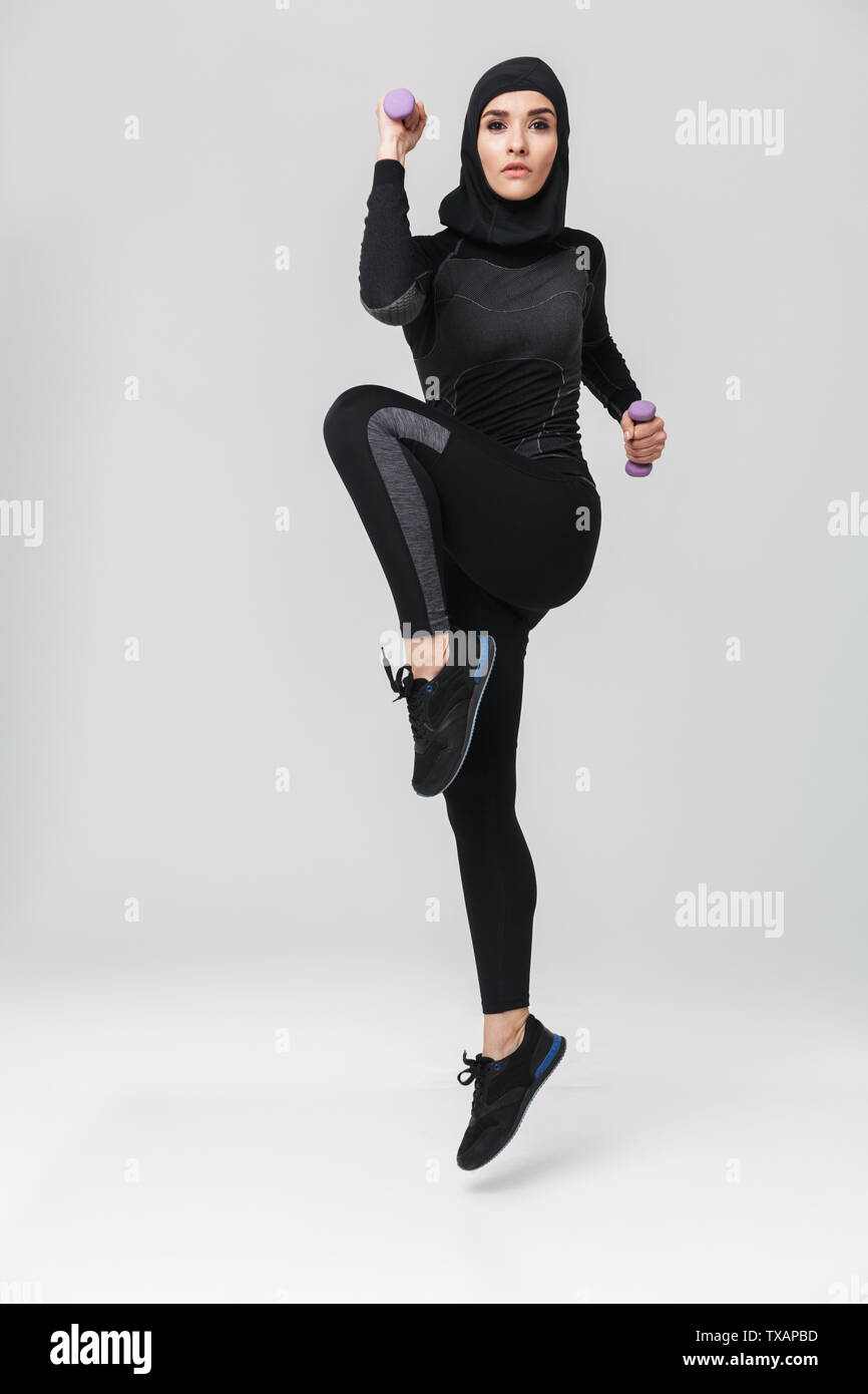 Image of young woman fitness muslim posing isolated over white wall ...