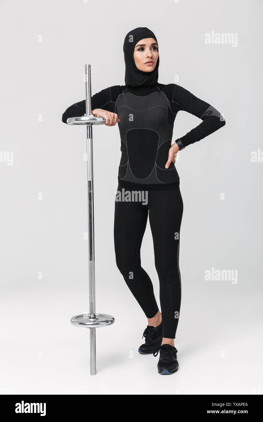 Image of young woman fitness muslim posing with barbell isolated over ...
