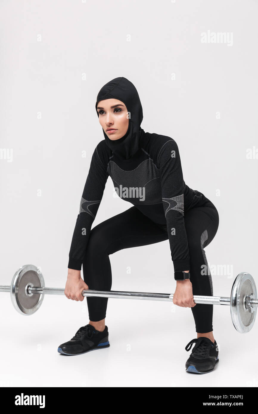 Image of young woman fitness muslim posing with barbell isolated over ...