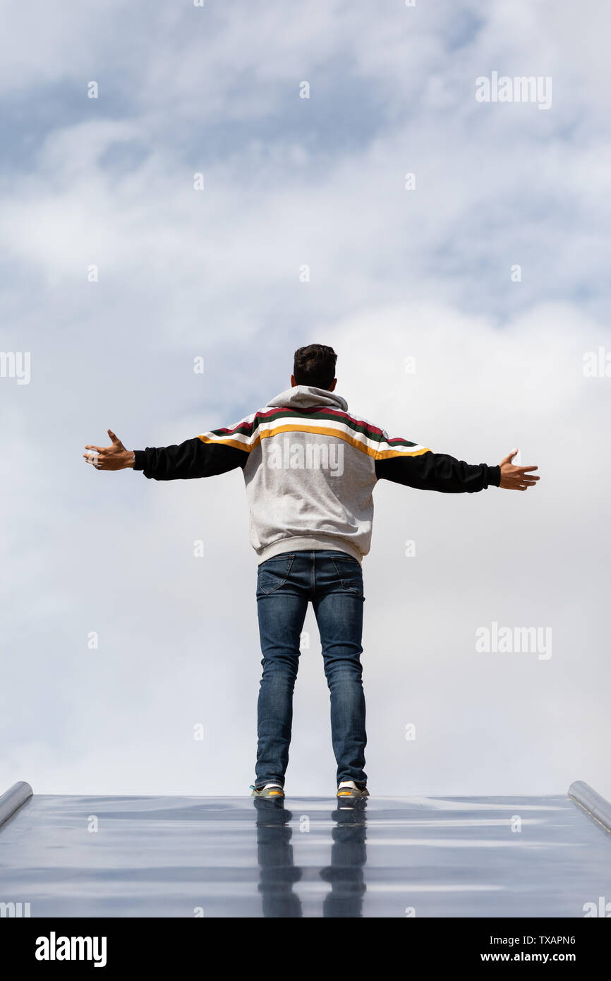 Young male standing, looking with a reflective attitude towards the ...