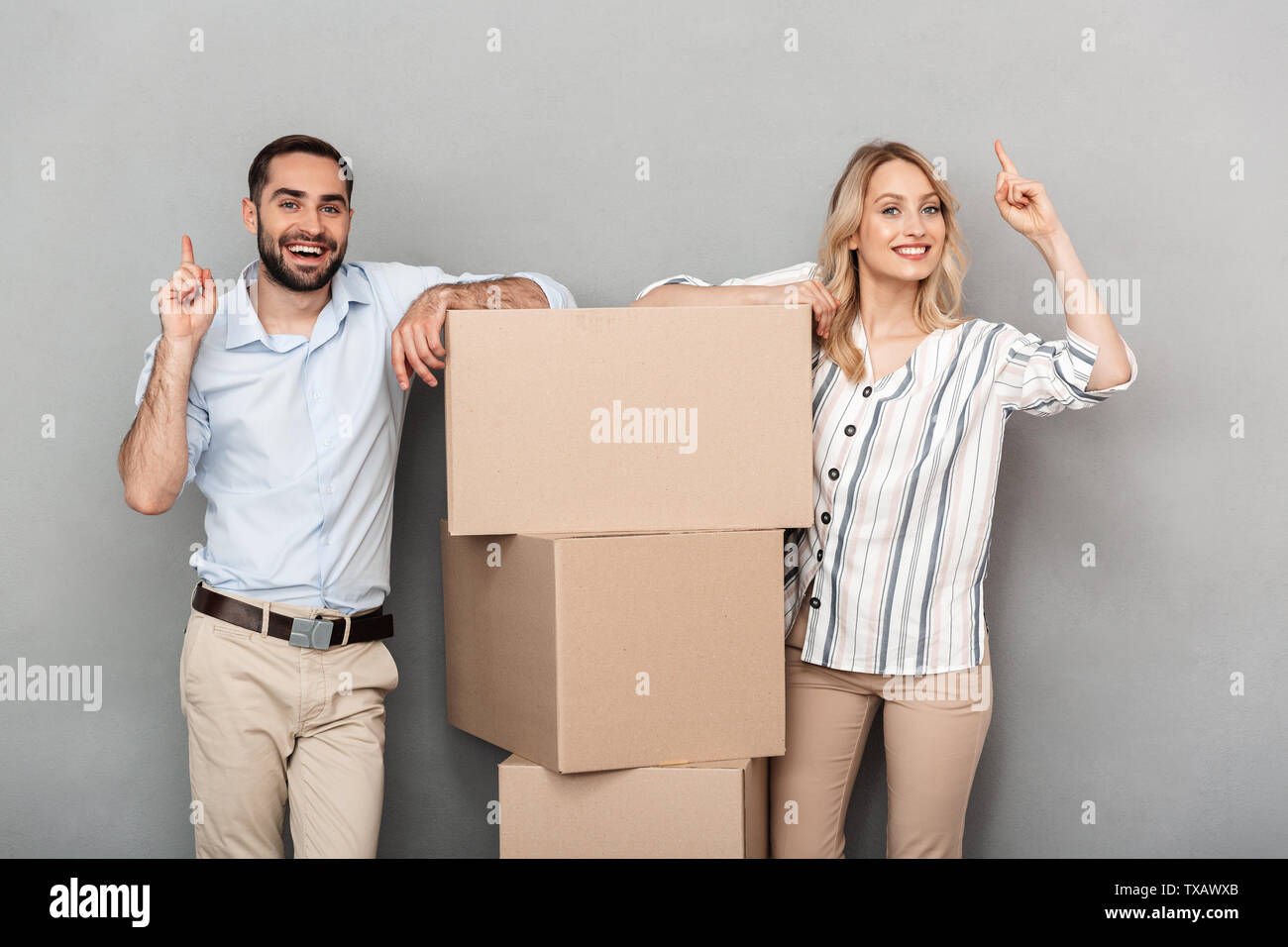 Photo of laughing couple in casual clothing standing near cardboard ...