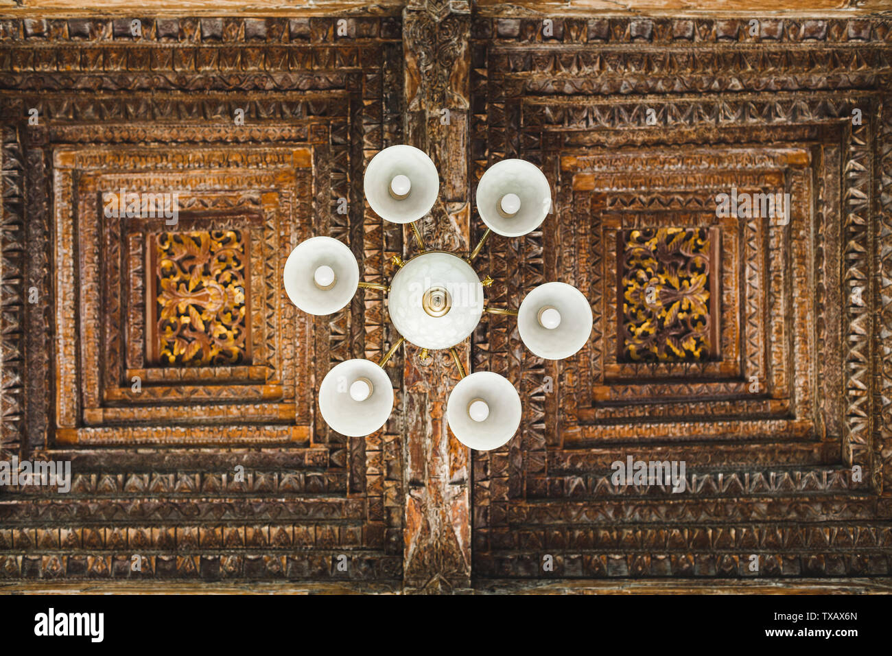 White chandelier on background of handmade wooden ceiling roof in ...