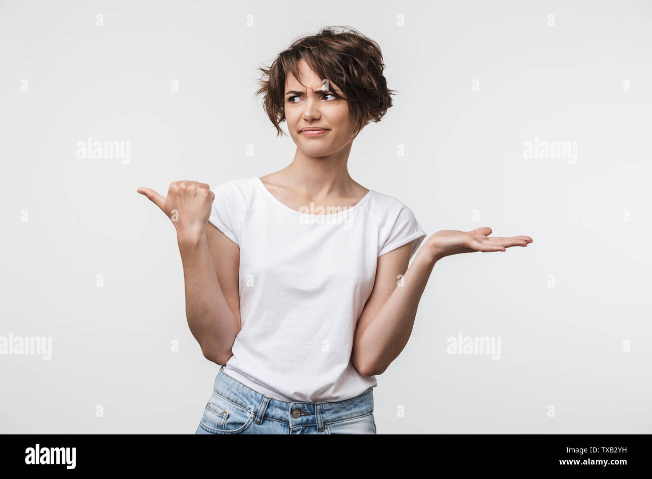 Image of confused woman with short hair in basic t-shirt pointing ...