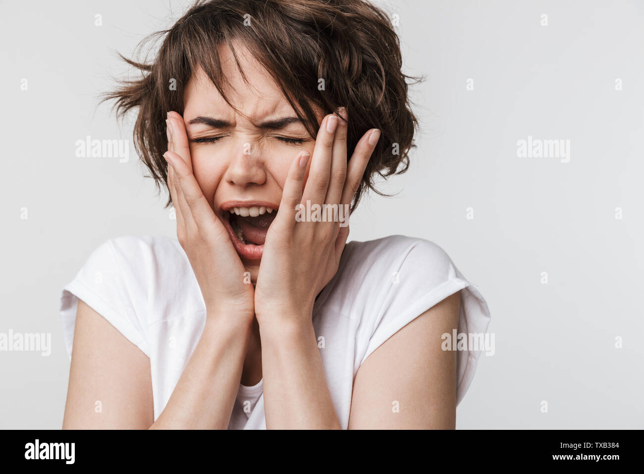Photo of intimidated woman with short brown hair in basic t-shirt ...