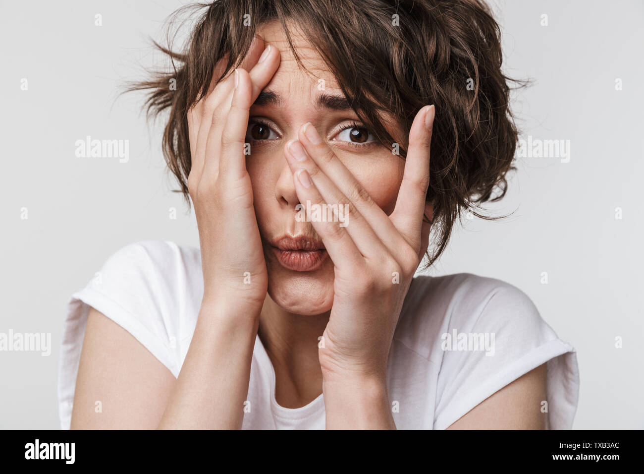Photo of perplexed woman with short brown hair in basic t-shirt keeping ...