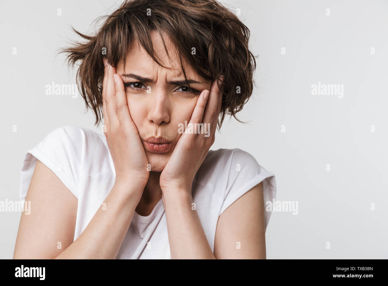 Photo of confused woman with short brown hair in basic t-shirt keeping ...