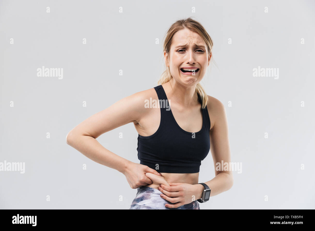 Image of upset blond woman 20s dressed in sportswear crying while ...