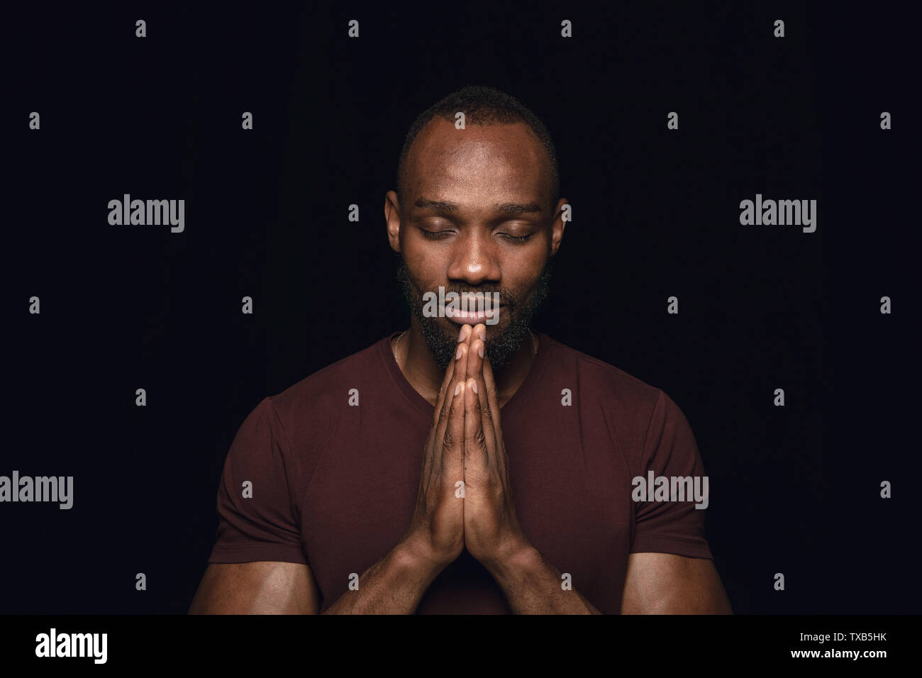 Close up portrait of young man isolated on black studio background ...