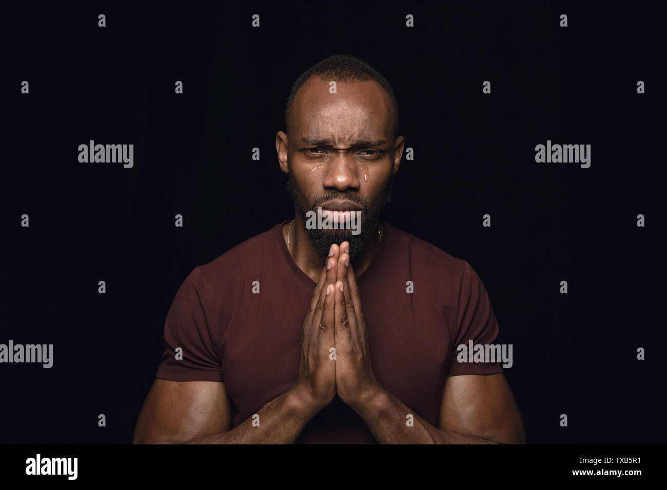 Close up portrait of young man isolated on black studio background ...