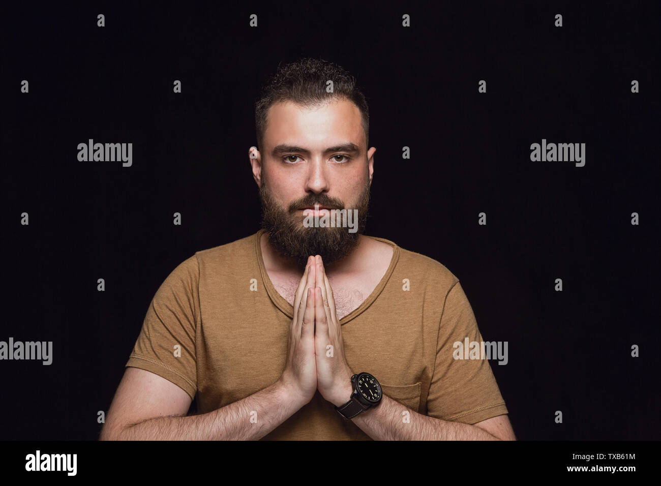 Close up portrait of young man isolated on black studio background ...