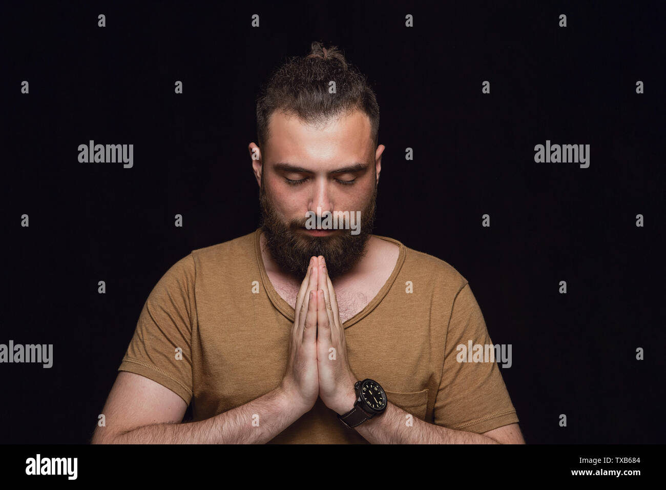 Close up portrait of young man isolated on black studio background ...