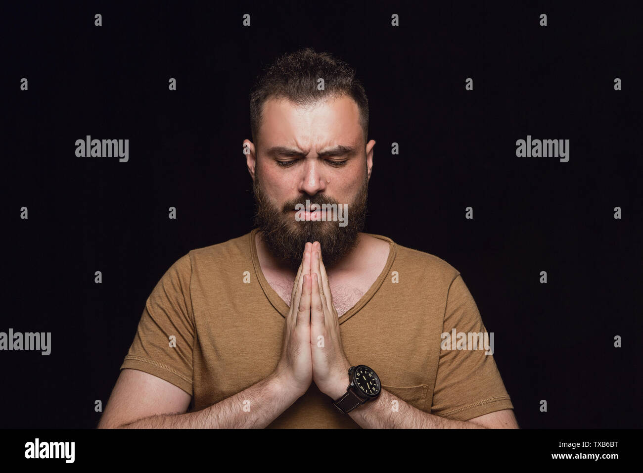 Close up portrait of young man isolated on black studio background ...