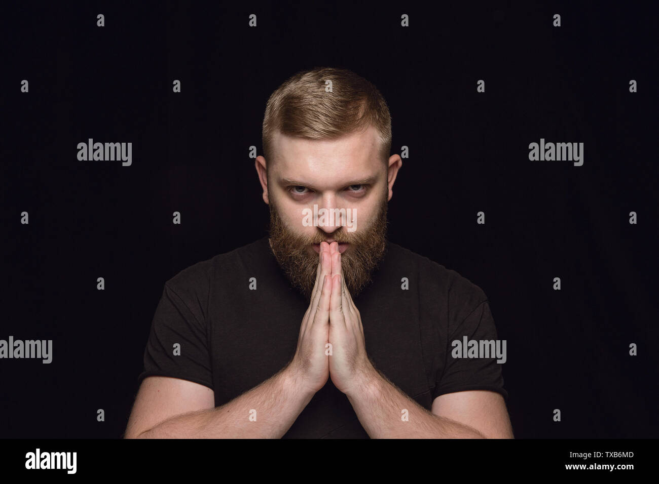 Close up portrait of young man isolated on black studio background ...