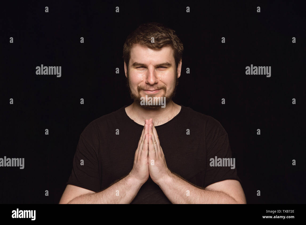Close up portrait of young man isolated on black studio background ...