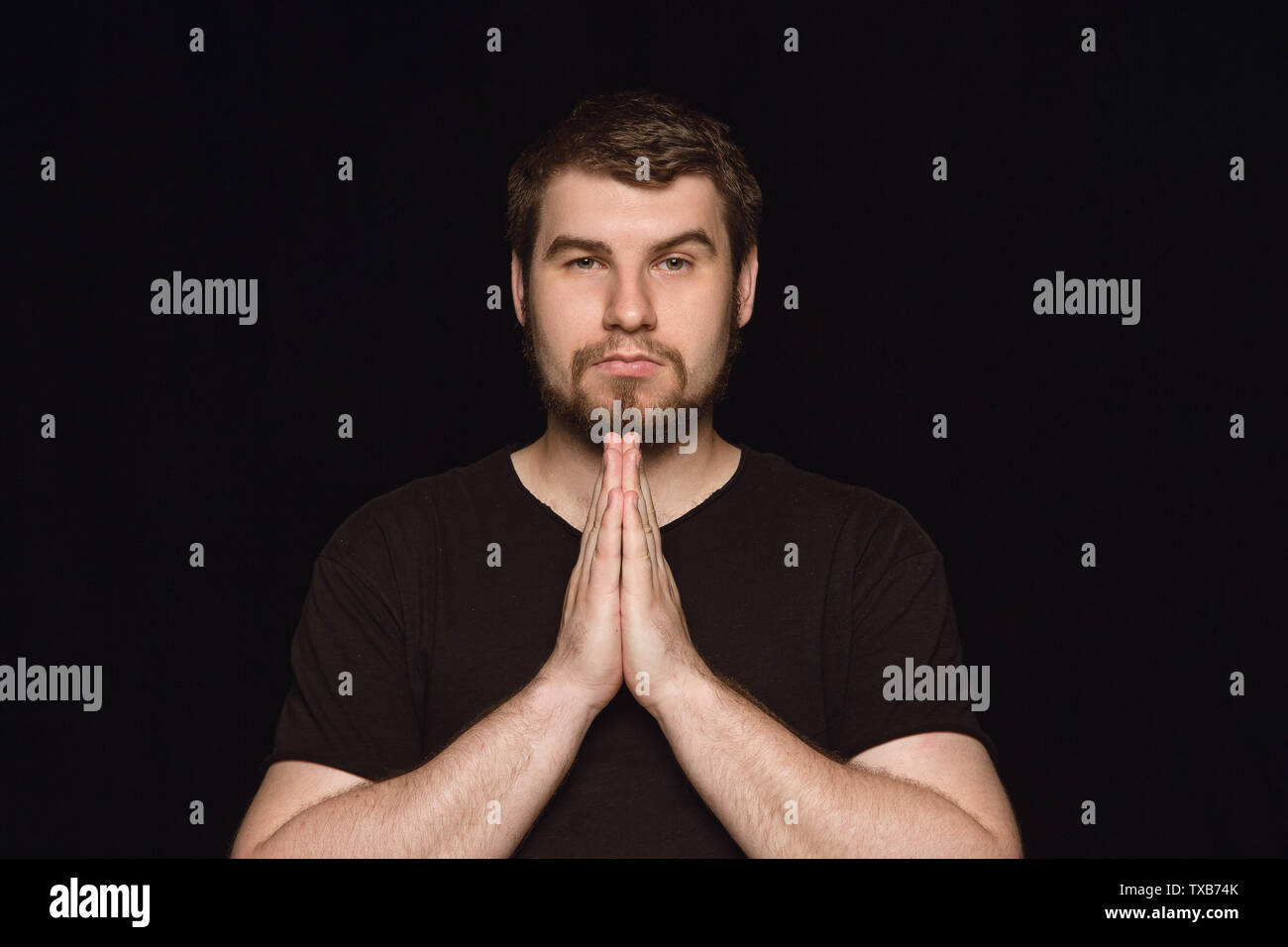 Close up portrait of young man isolated on black studio background ...