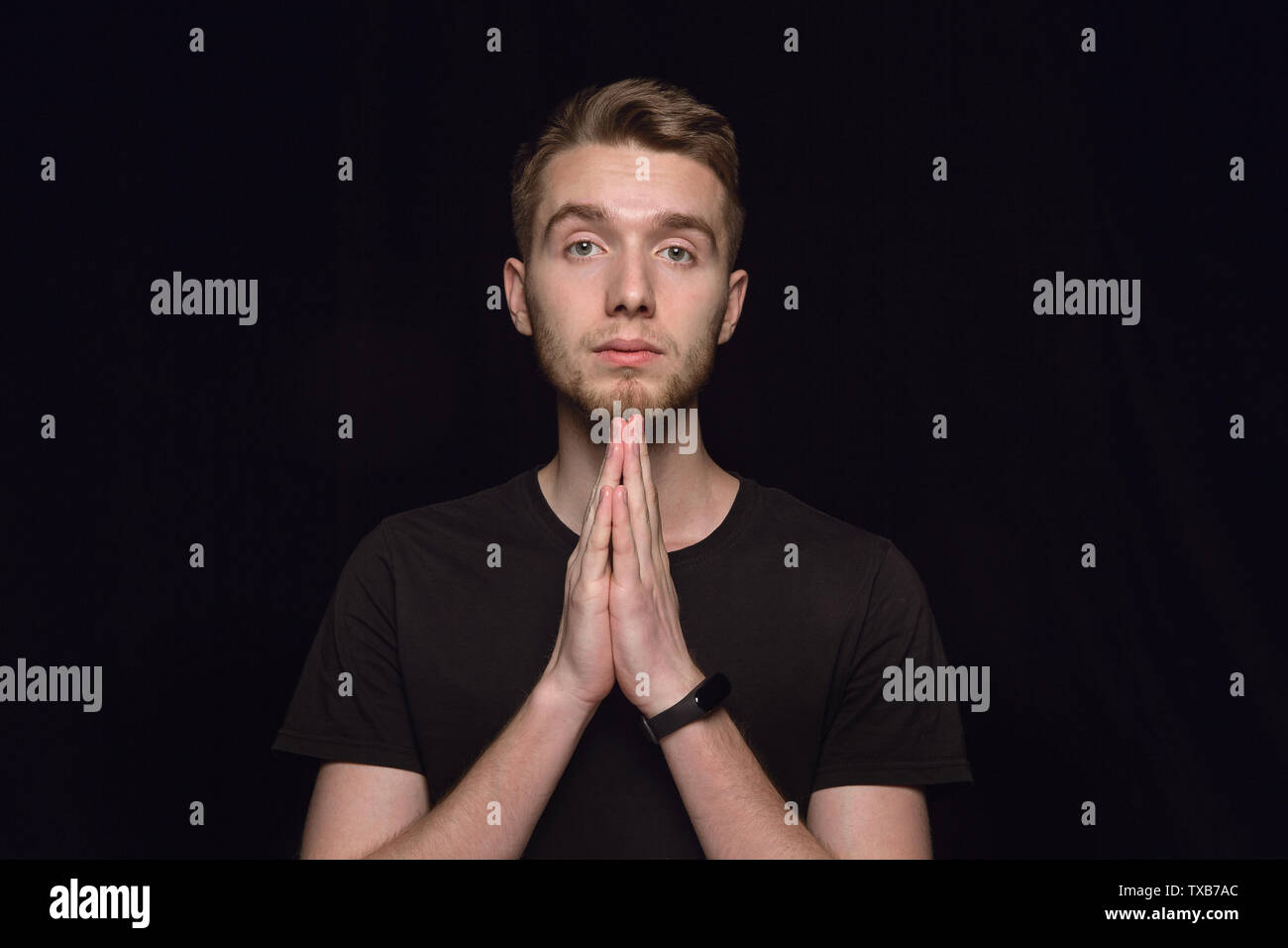 Close up portrait of young man isolated on black studio background ...