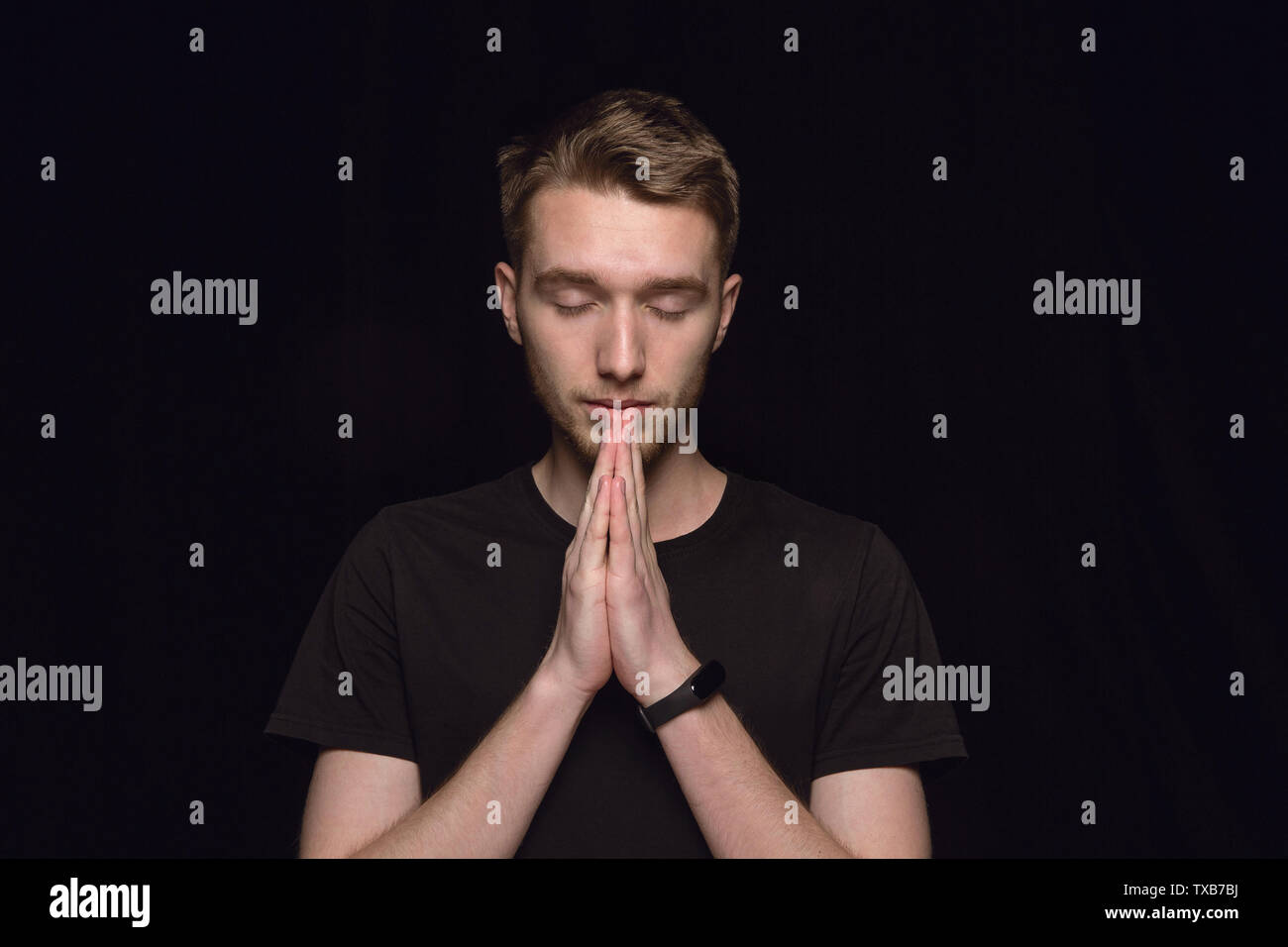 Close up portrait of young man isolated on black studio background ...